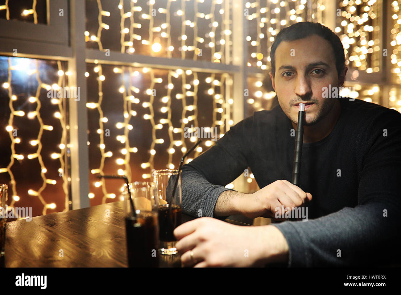 man holding hookah pipe and smoking in a night club Stock Photo - Alamy