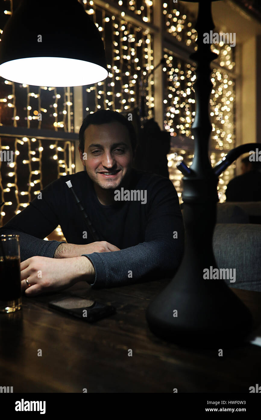 man holding hookah pipe and smoking in a night club Stock Photo - Alamy