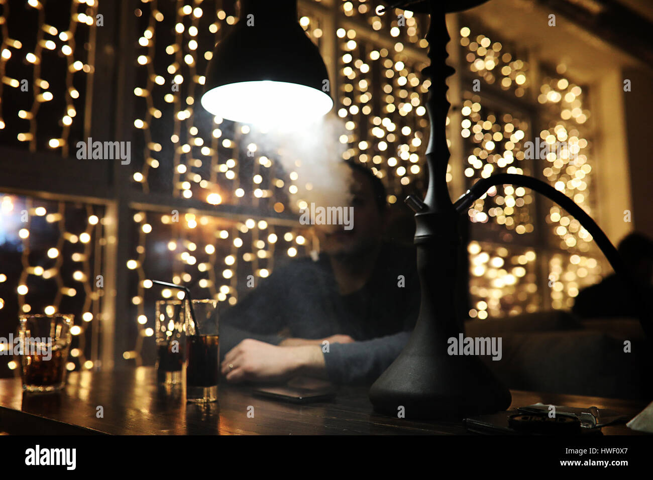 man holding hookah pipe and smoking in a night club Stock Photo - Alamy
