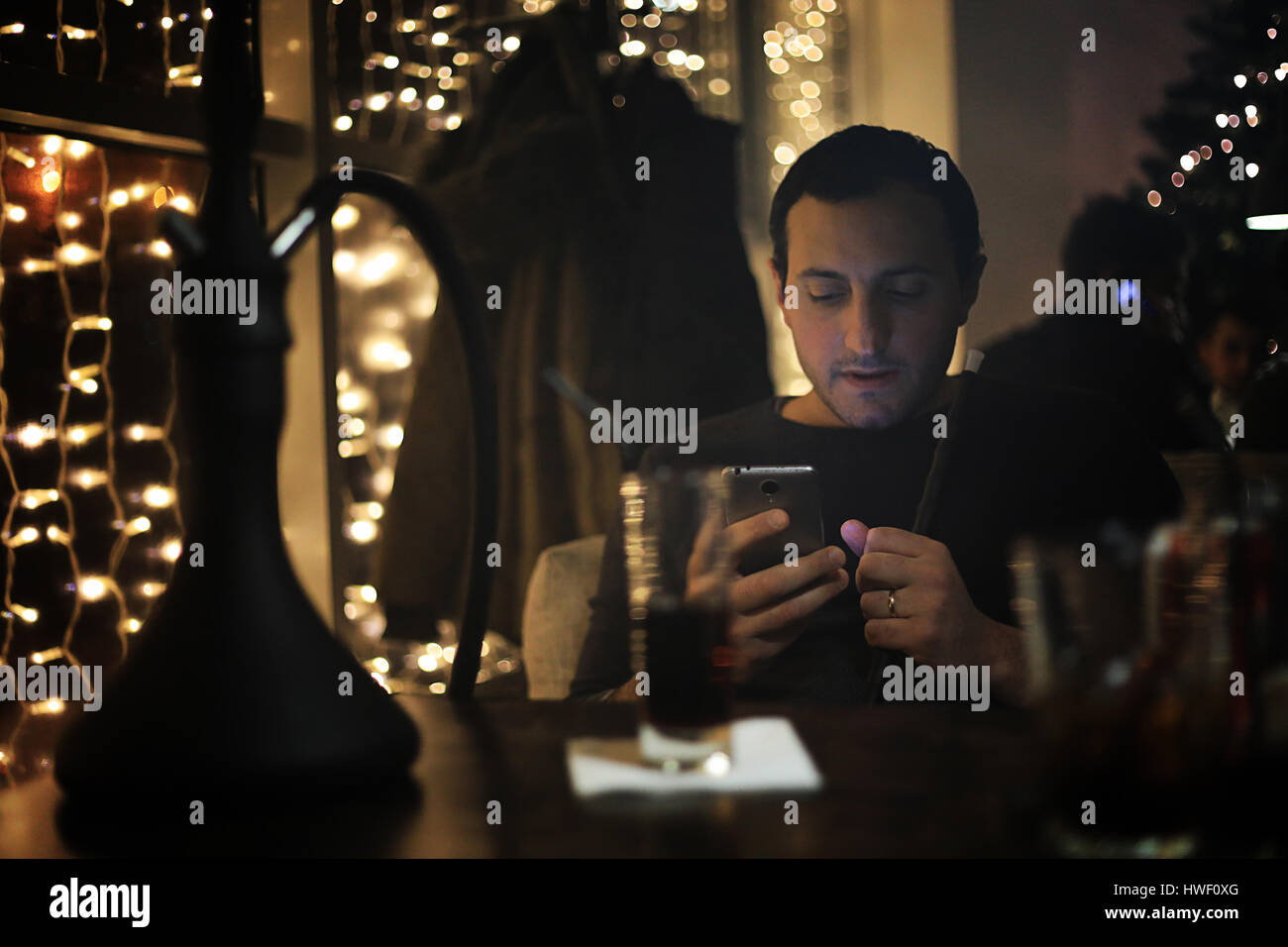 man holding hookah pipe and smoking in a night club Stock Photo - Alamy