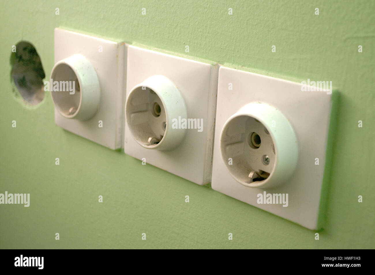 Three white European 220V power socket on green wall in Novi Sad ...