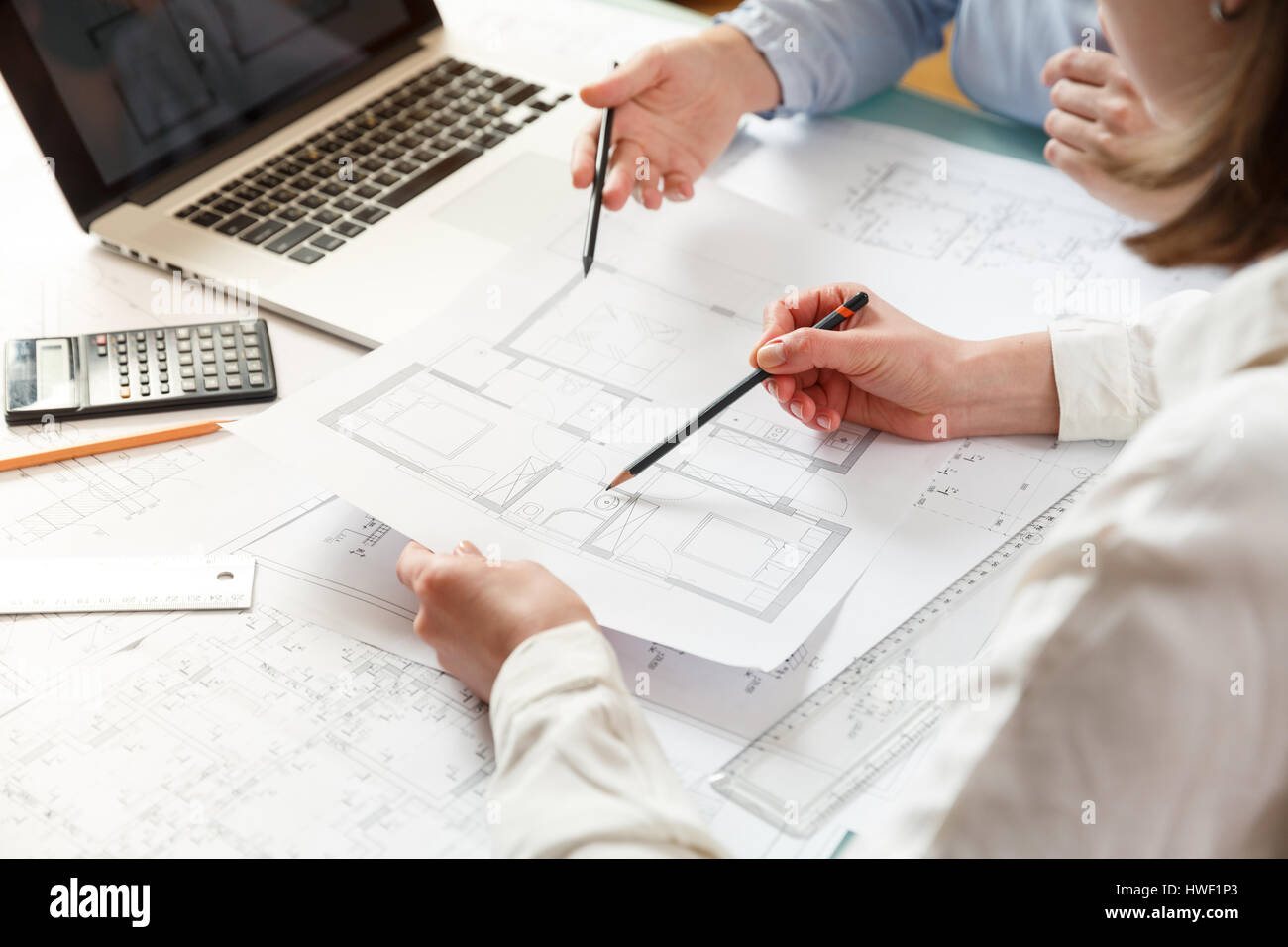Young female architect and designer working on blueprint project of new ...