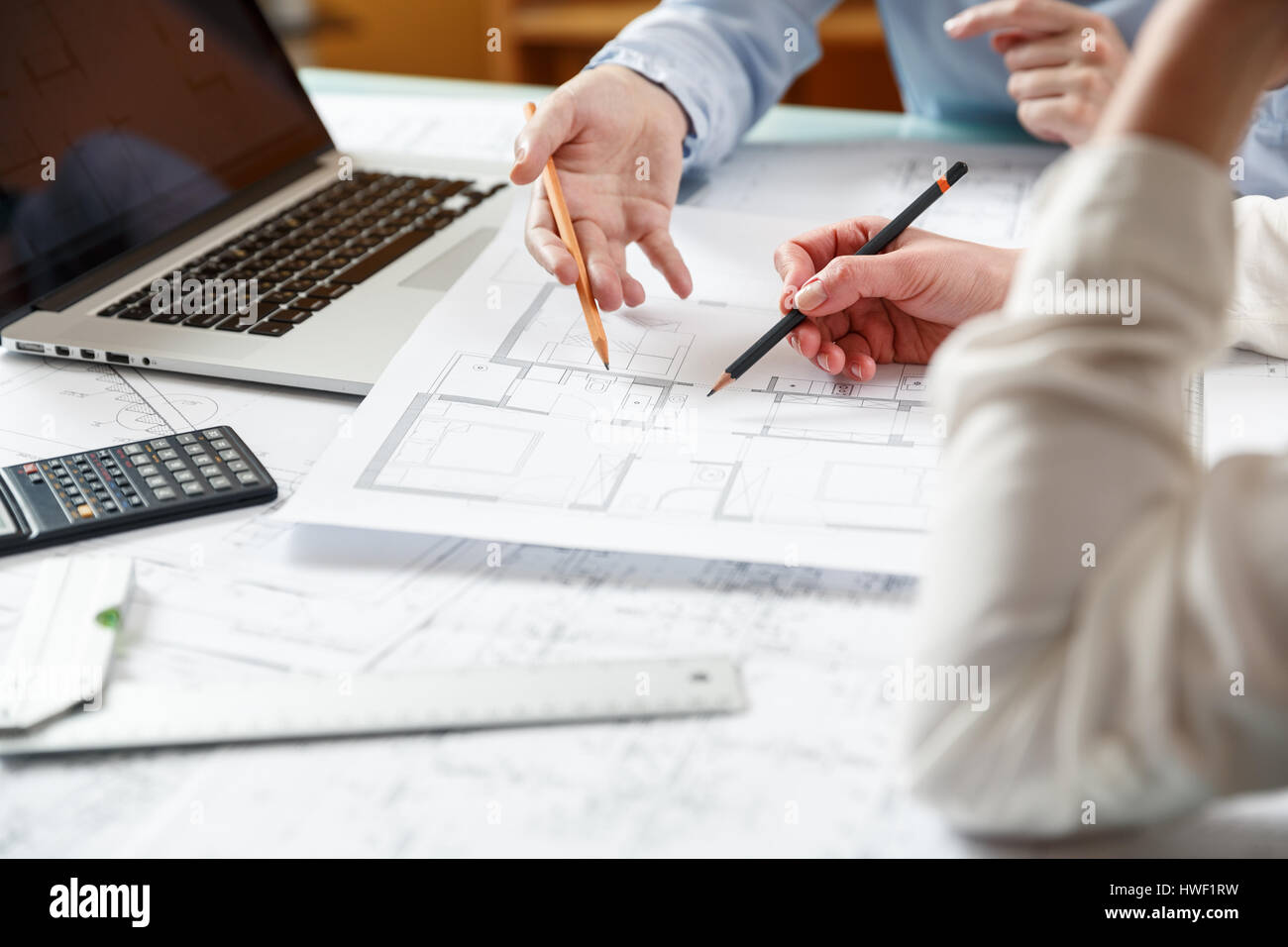 Young female architect and designer working on blueprint project of new ...