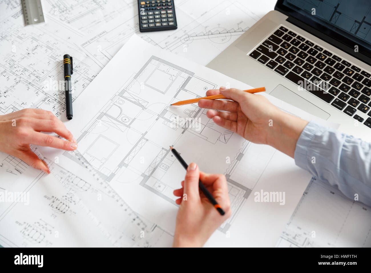 Young female architect and designer working on blueprint project of new ...
