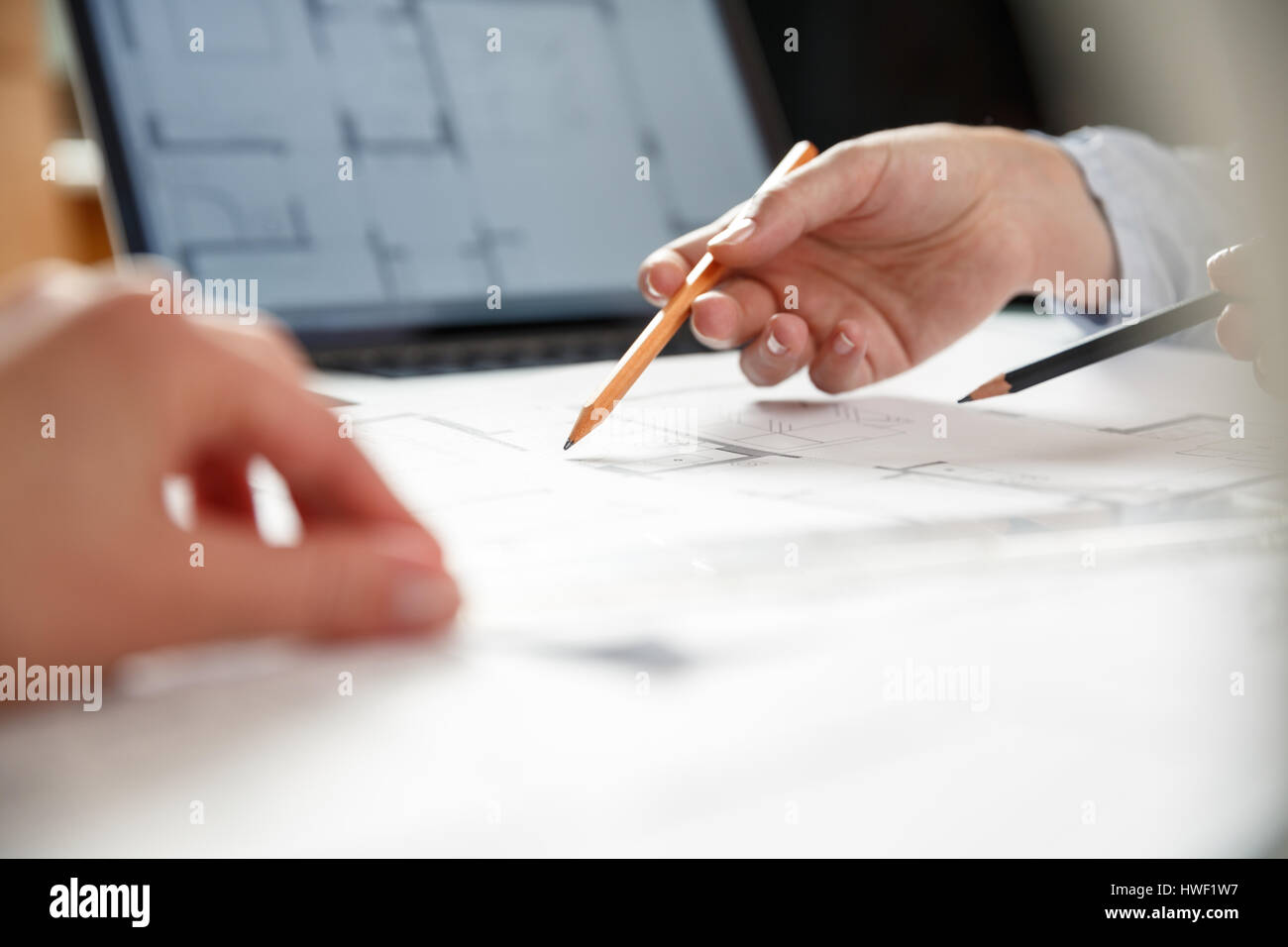 Young female architect and designer working on blueprint project of new ...