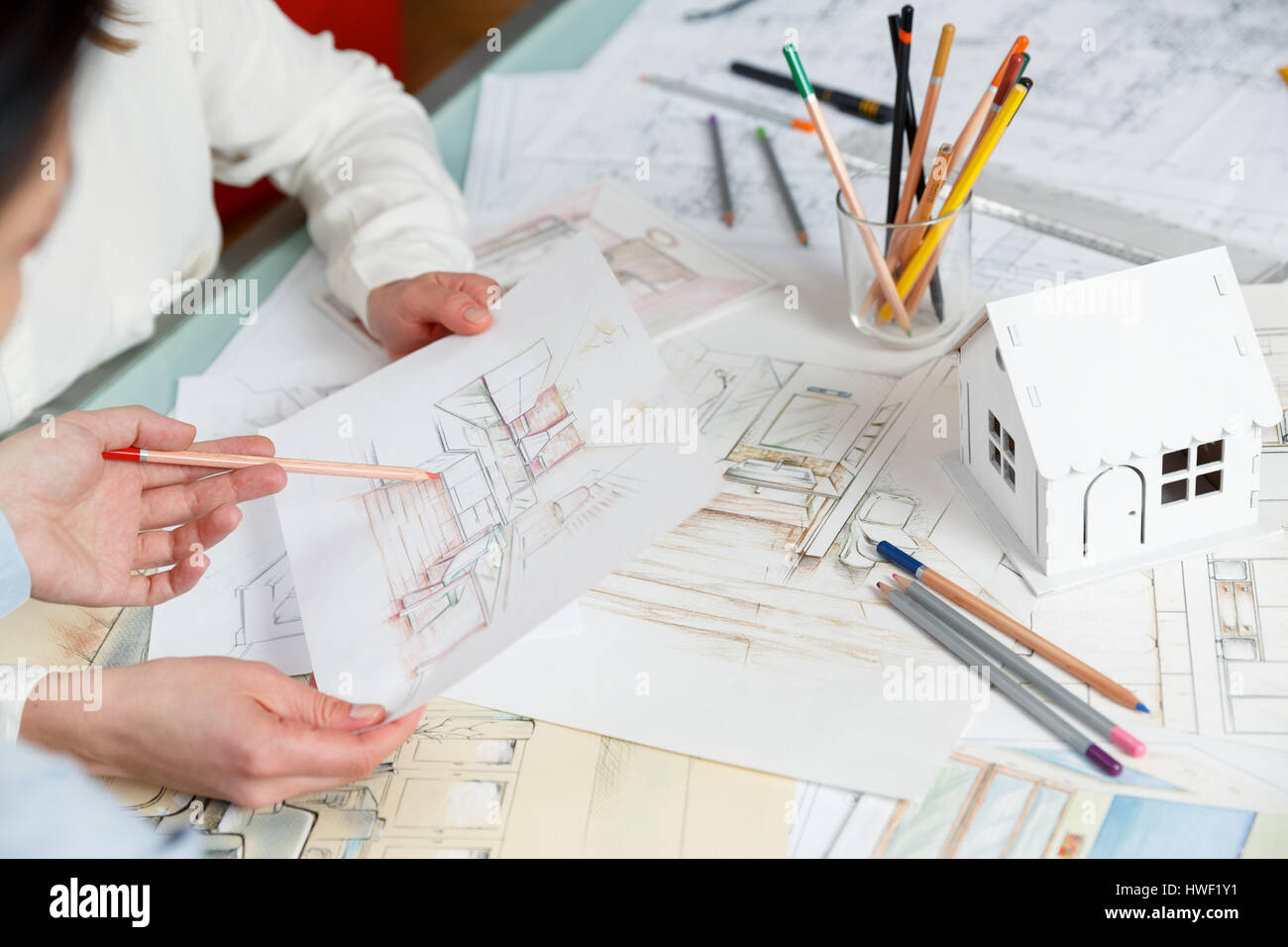 Interior designers working on color hand drawings of a kitchen interior ...