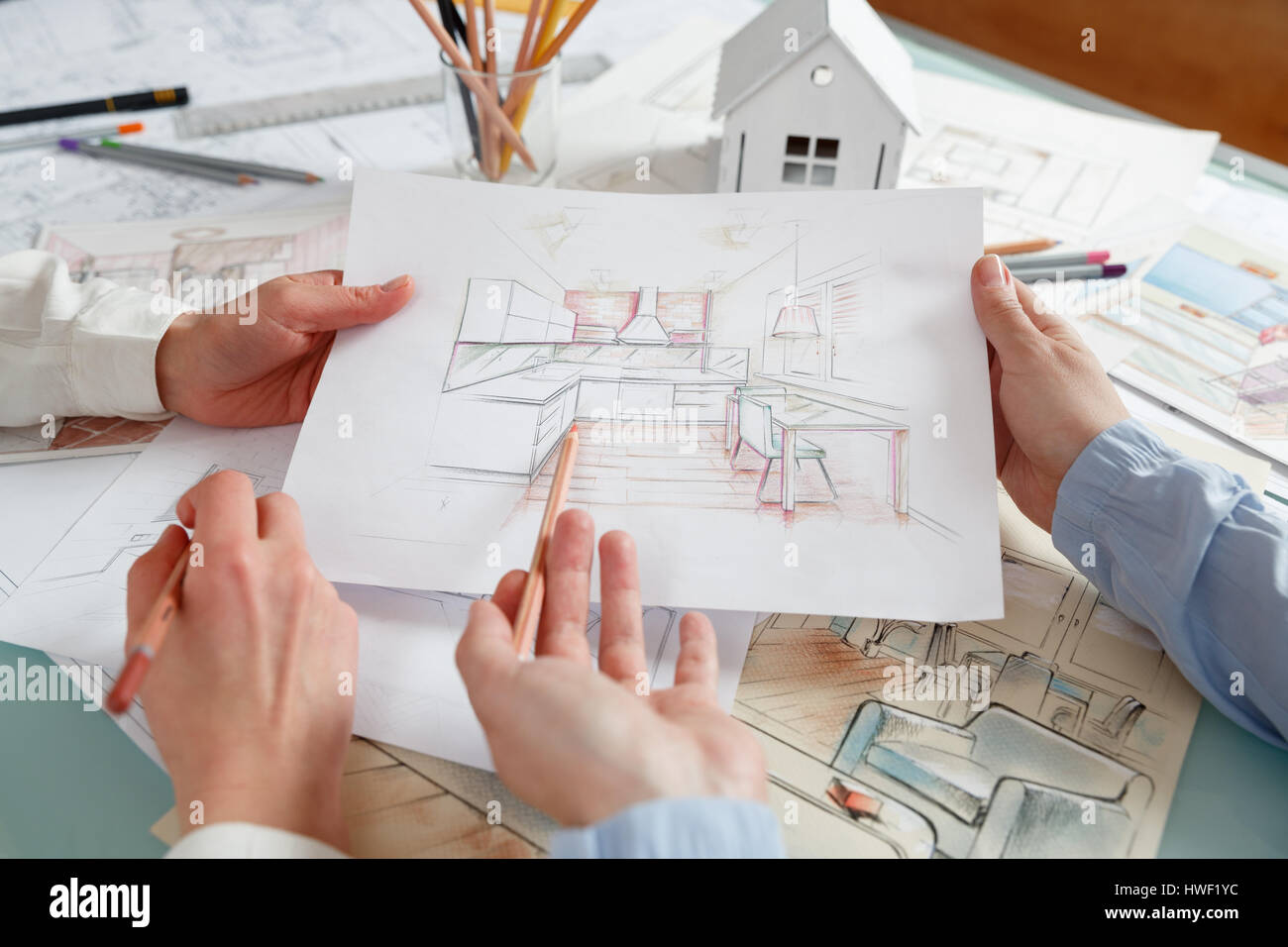 Interior designers working on color hand drawings of a kitchen interior ...