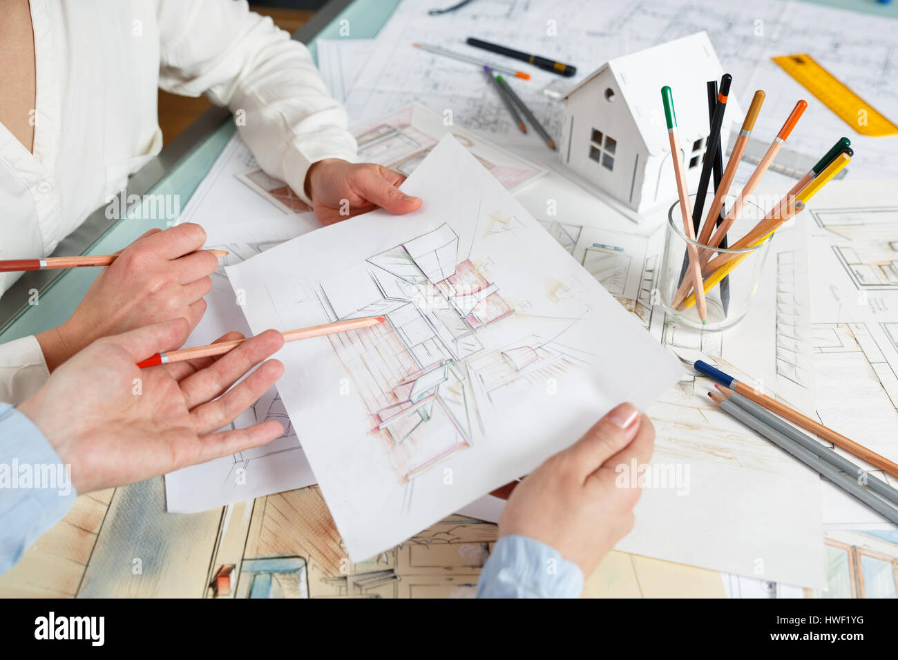Interior designers working on color hand drawings of a kitchen interior ...