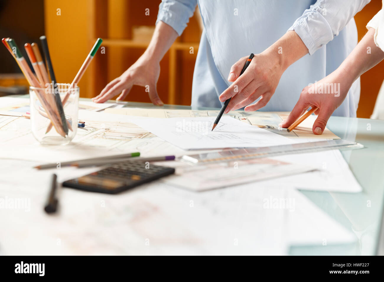 Interior designers working on hand drawings of interior at work place ...