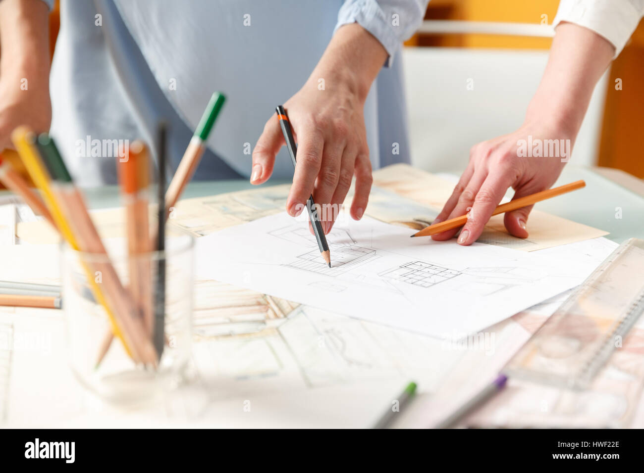 Interior designers working on hand drawings of interior at work place ...