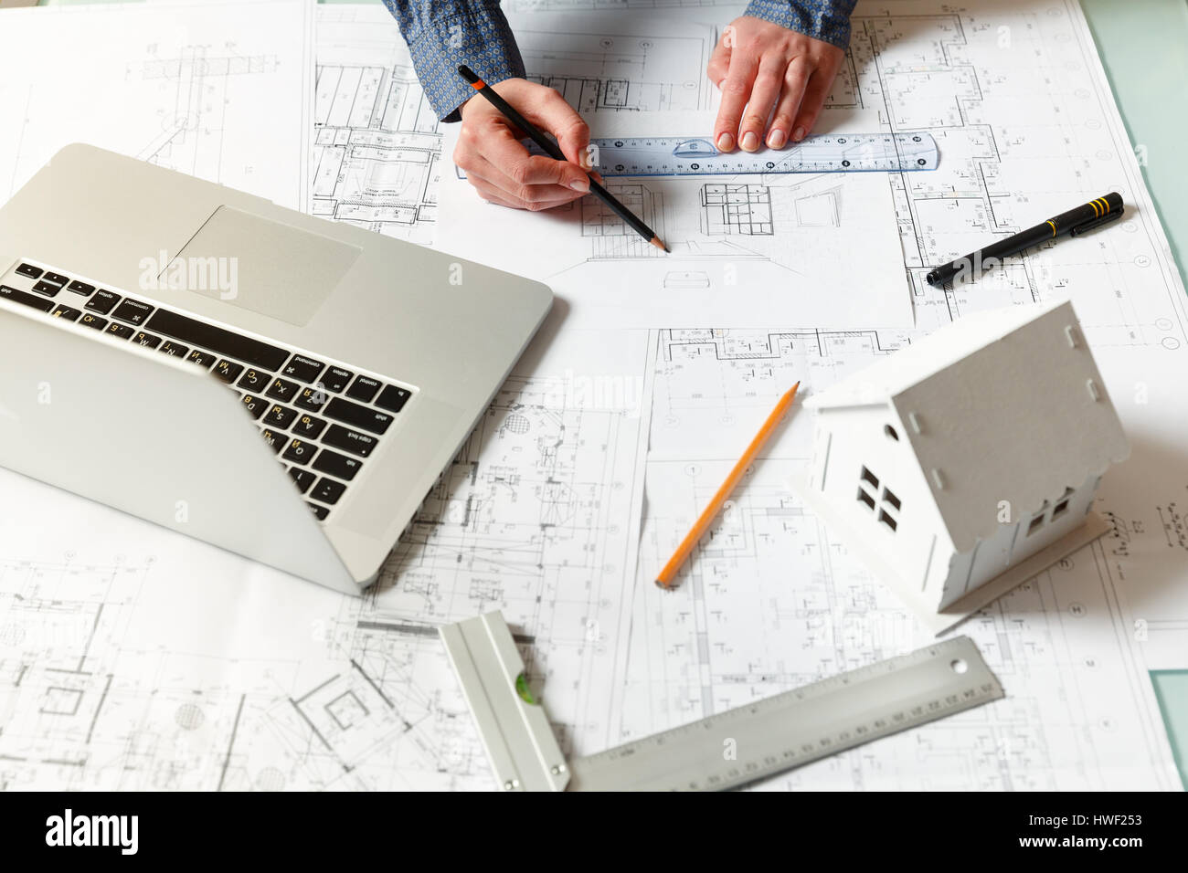 Young female architect and designer working on blueprint project of new ...