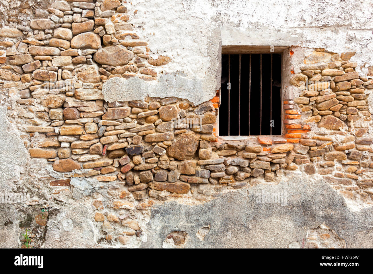 Aged and weathered masonry wall, with a window made by iron bars Stock ...