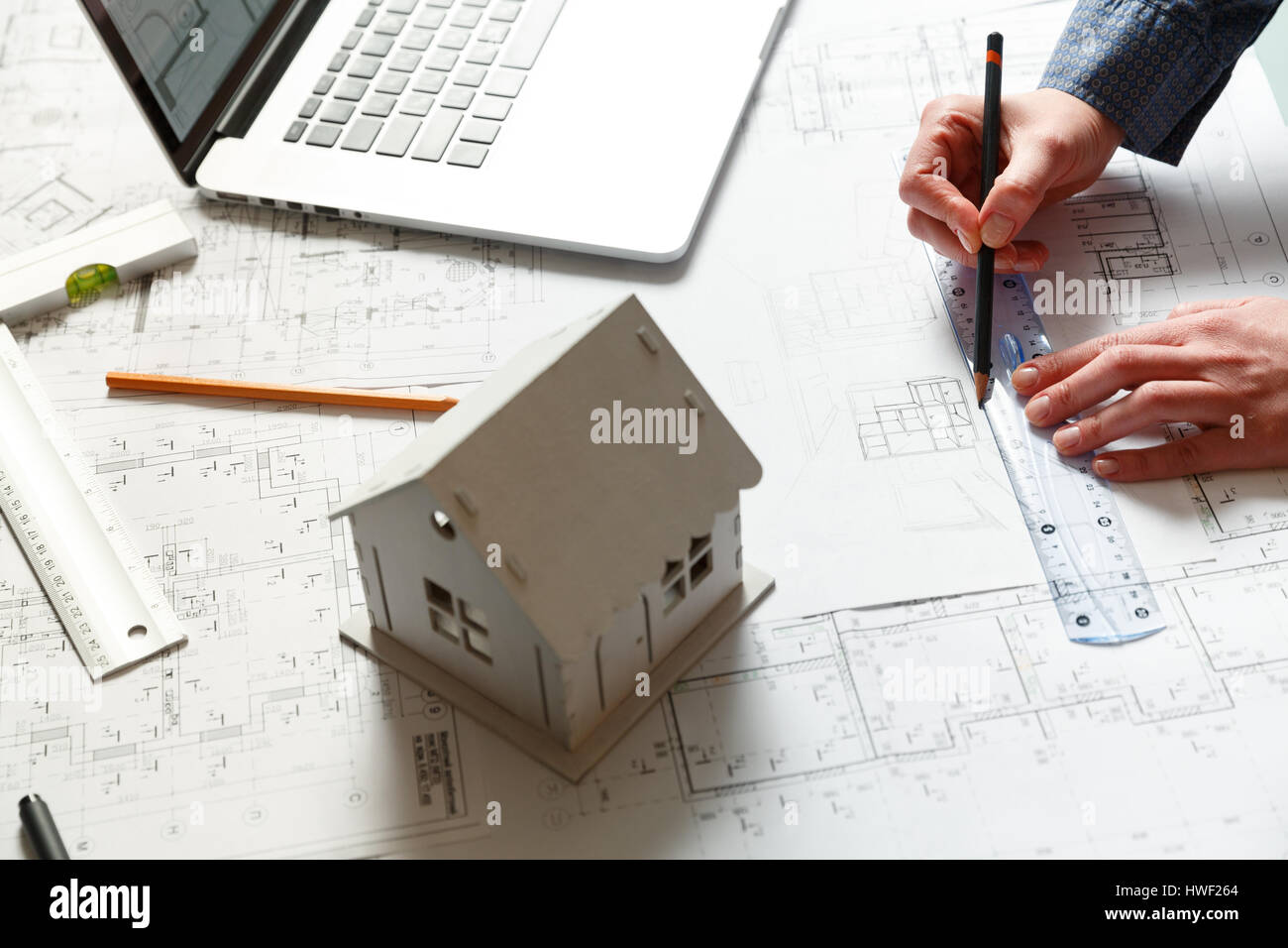Young female architect and designer working on blueprint project of new ...