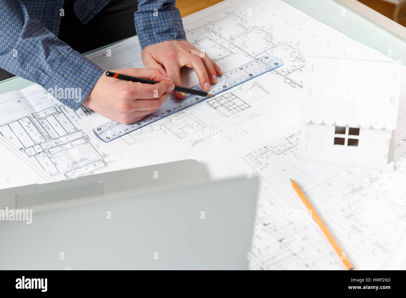 Young female architect and designer working on blueprint project of new ...