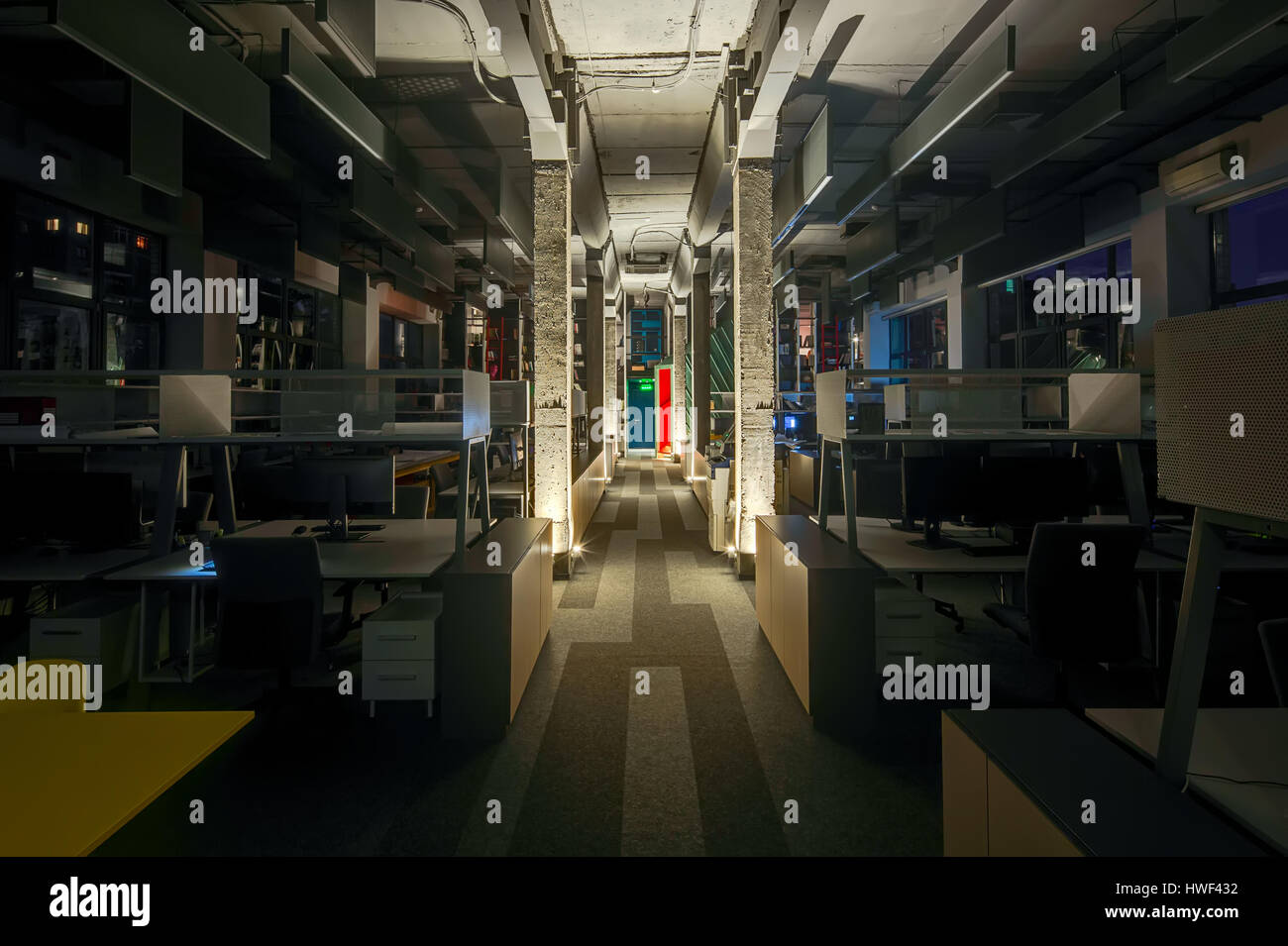 Luminous office in a loft style with gray walls, concrete columns and a ...