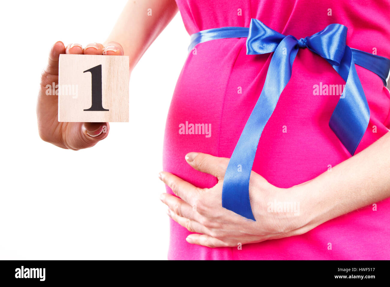 Pregnant woman in pink dress with blue ribbon showing number of first ...