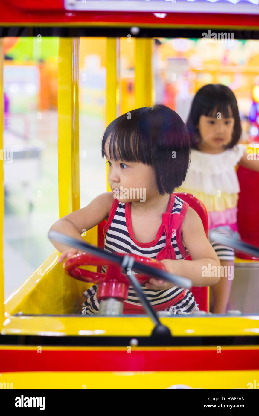 Asian Chinese Little Sister Driving Toy Bus at indoor playground Stock ...