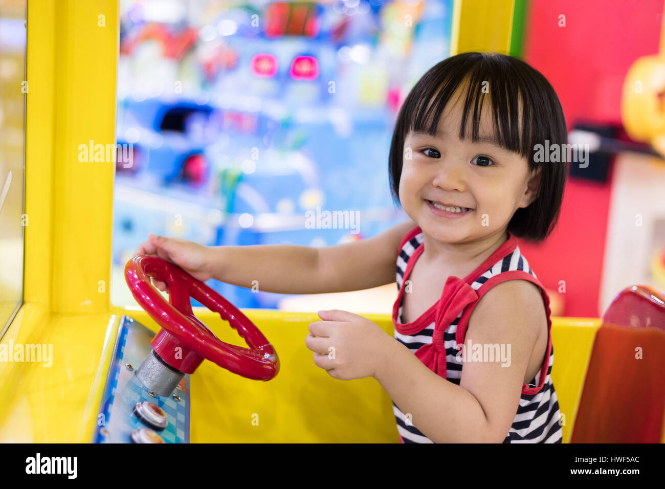 Happy Asian Chinese Little Girl Driving Toy Bus at indoor playground ...