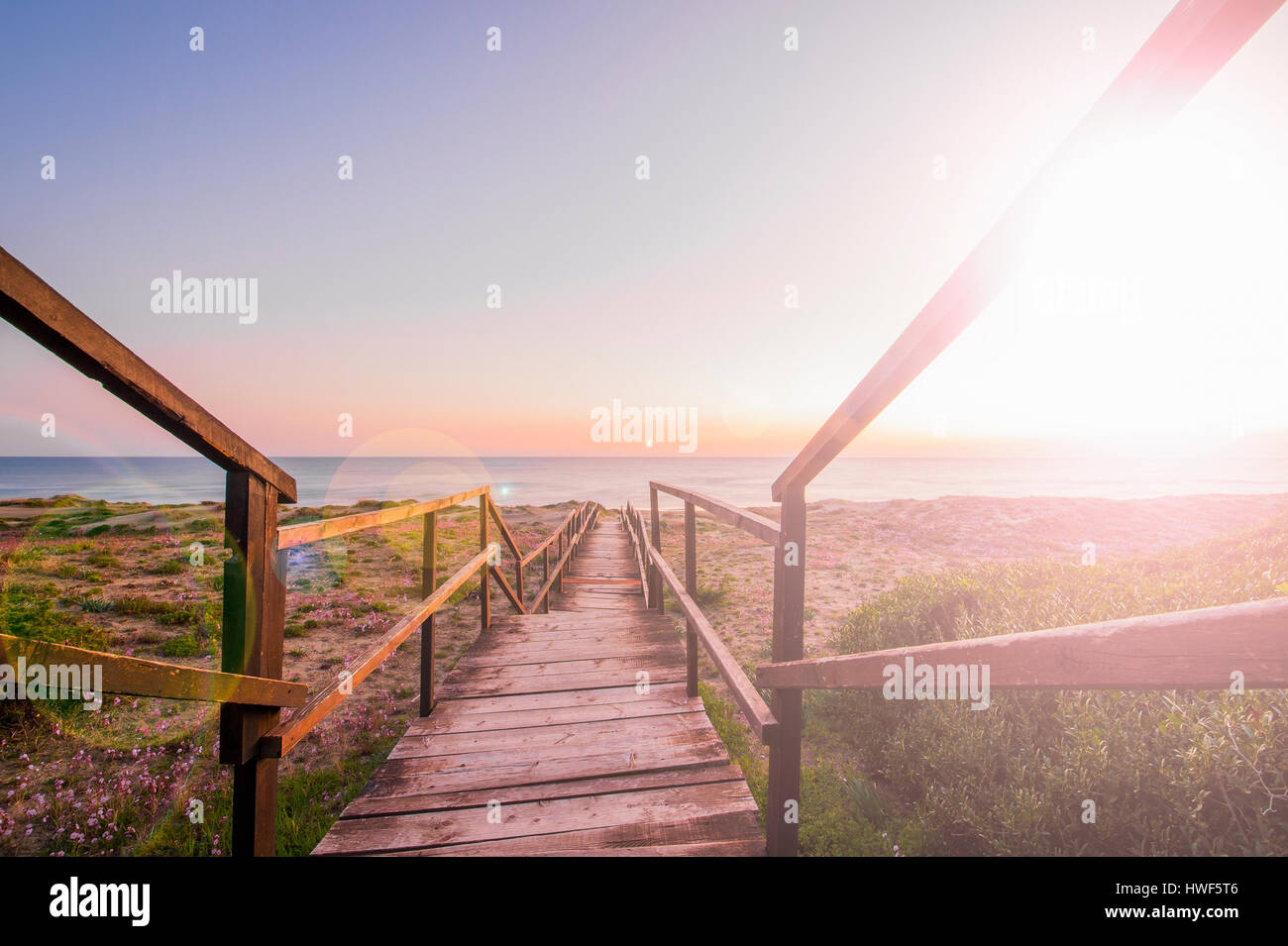 Boardwalk on a beach at sunset Stock Photo - Alamy