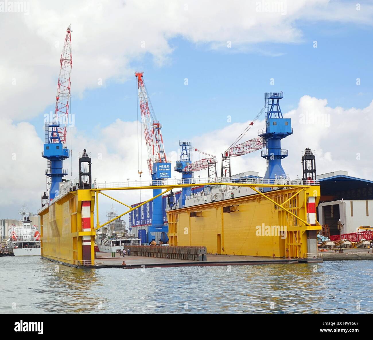 KAOHSIUNG, TAIWAN -- AUGUST 12, 2015: A floating dry dock is surrounded ...