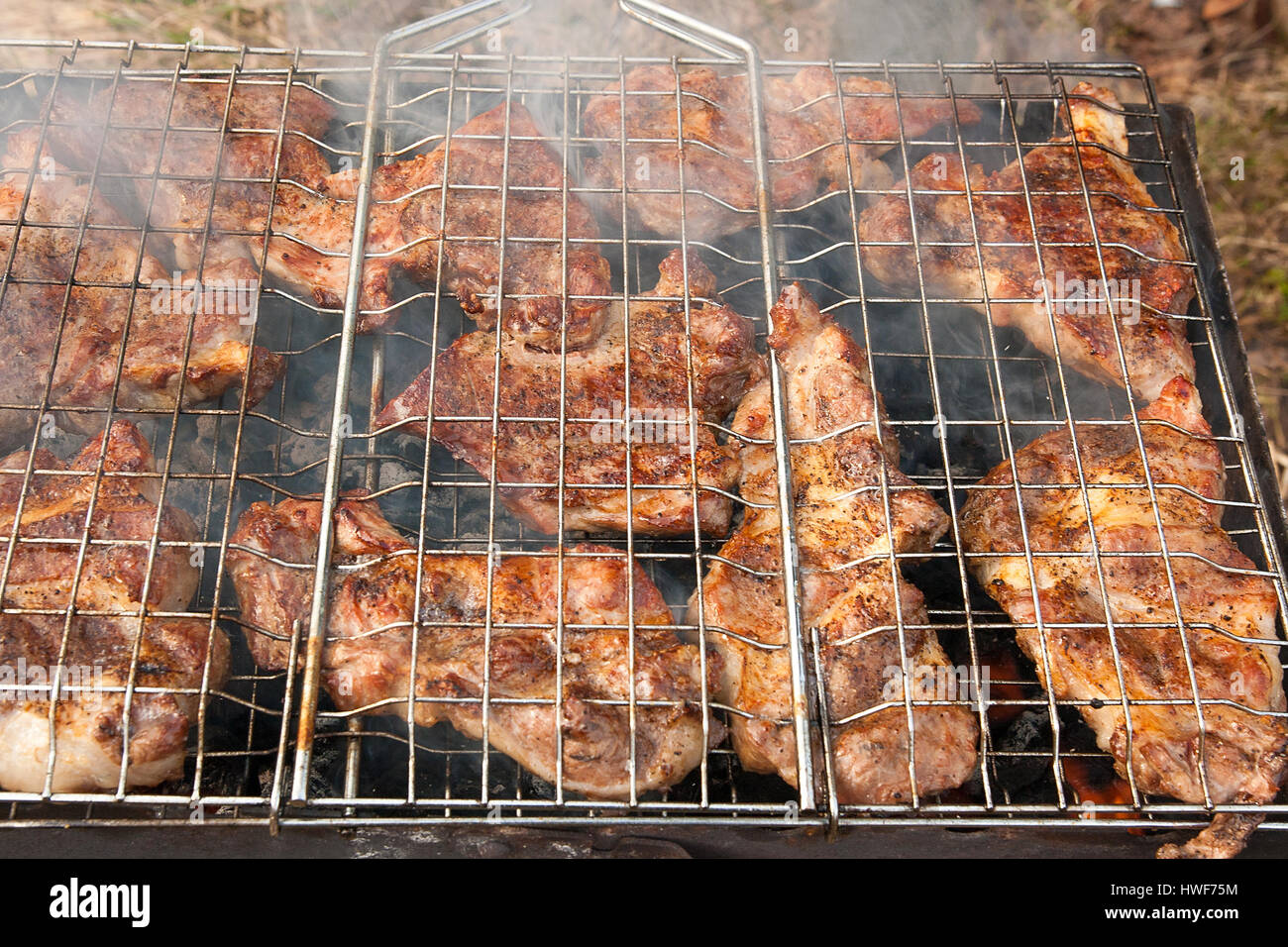 Juicy slices of meat cooking on an open flame grill. Roasted meat with ...