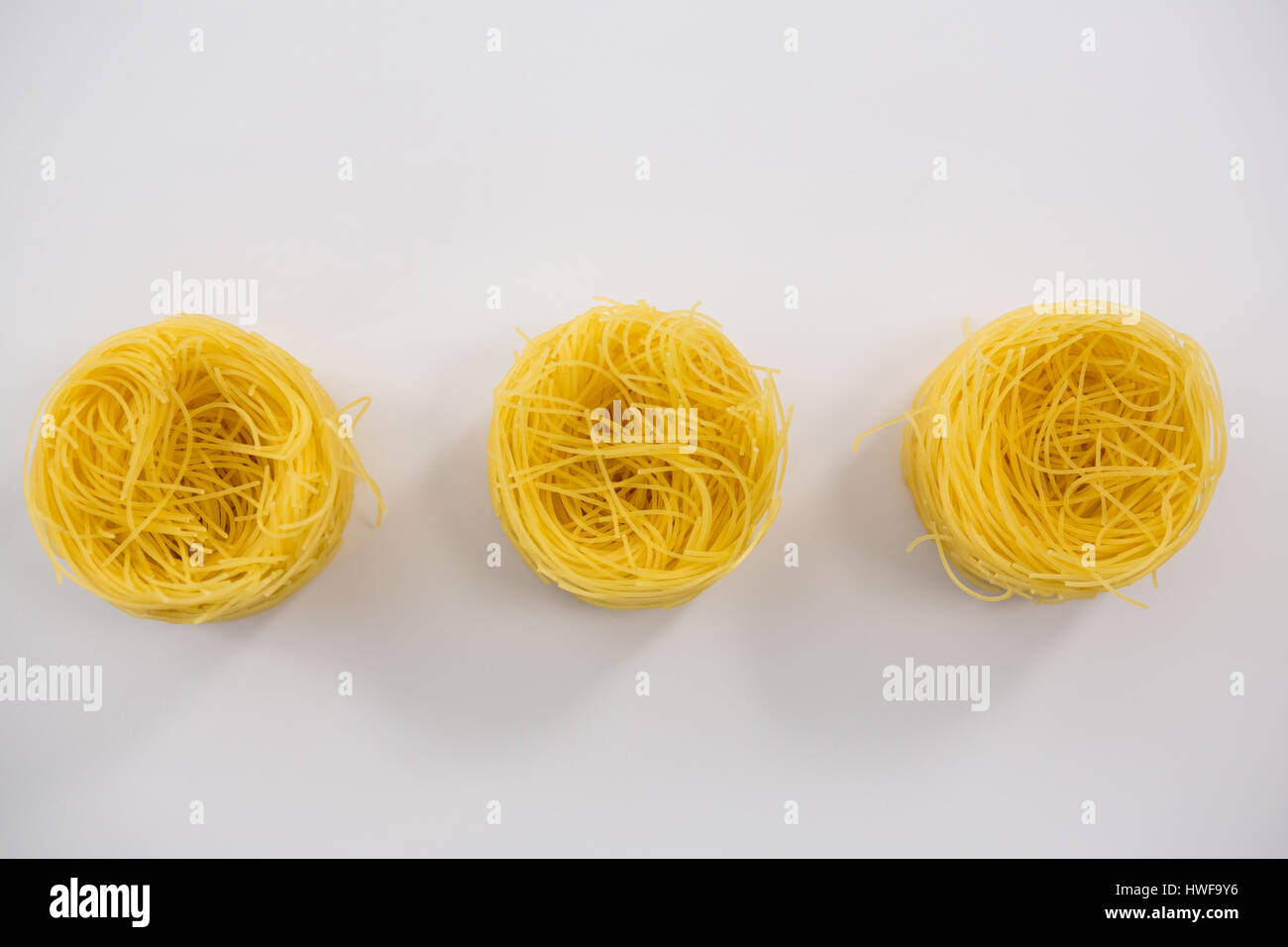 Capellini pasta arranged in a row on white background Stock Photo - Alamy