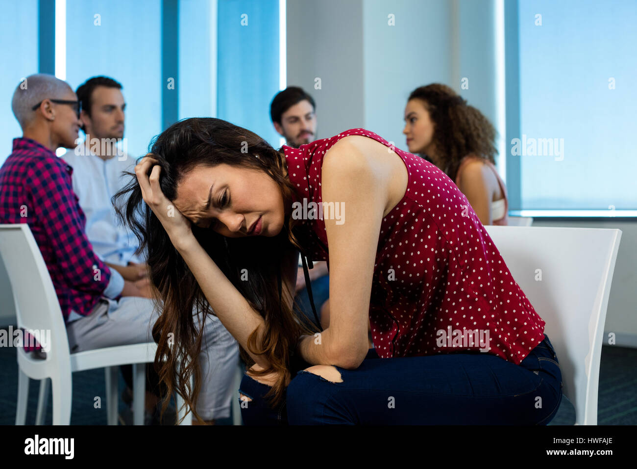 Woman crying while creative business team in background at office Stock ...