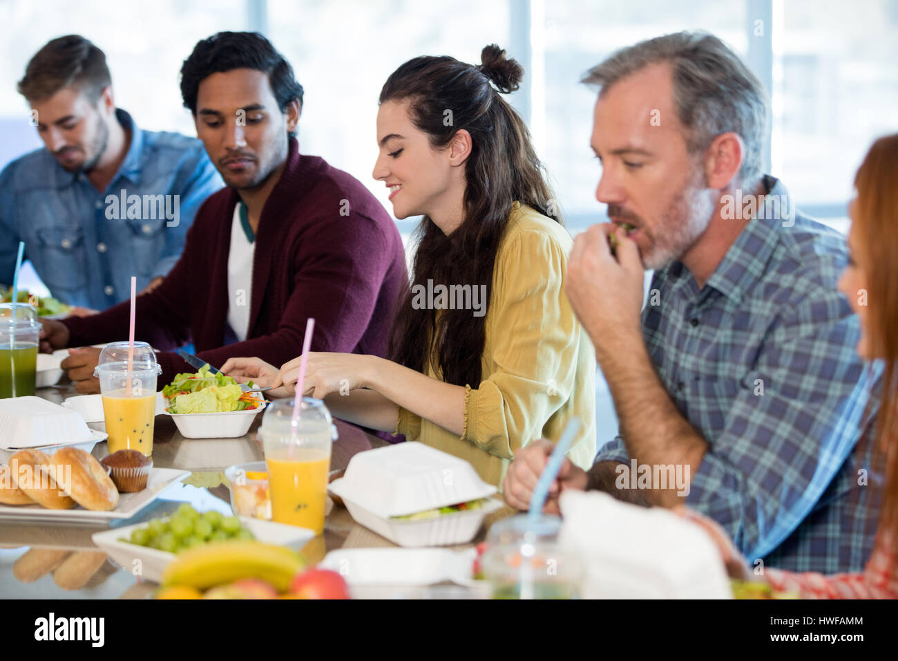 Creative business team having meal in office Stock Photo - Alamy