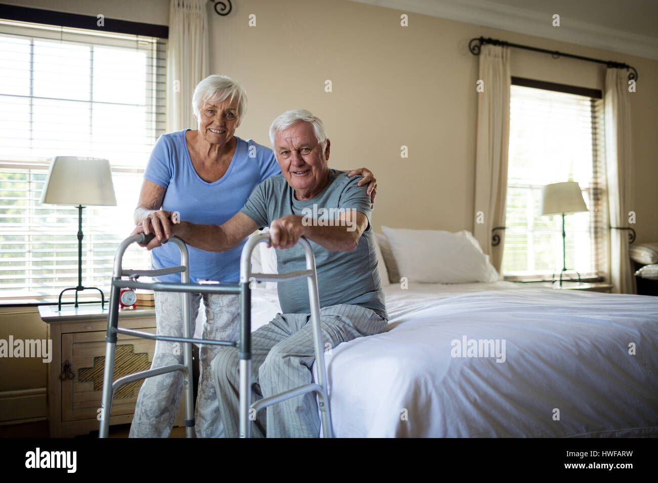 Senior woman helping man to walk with a walker at home Stock Photo - Alamy