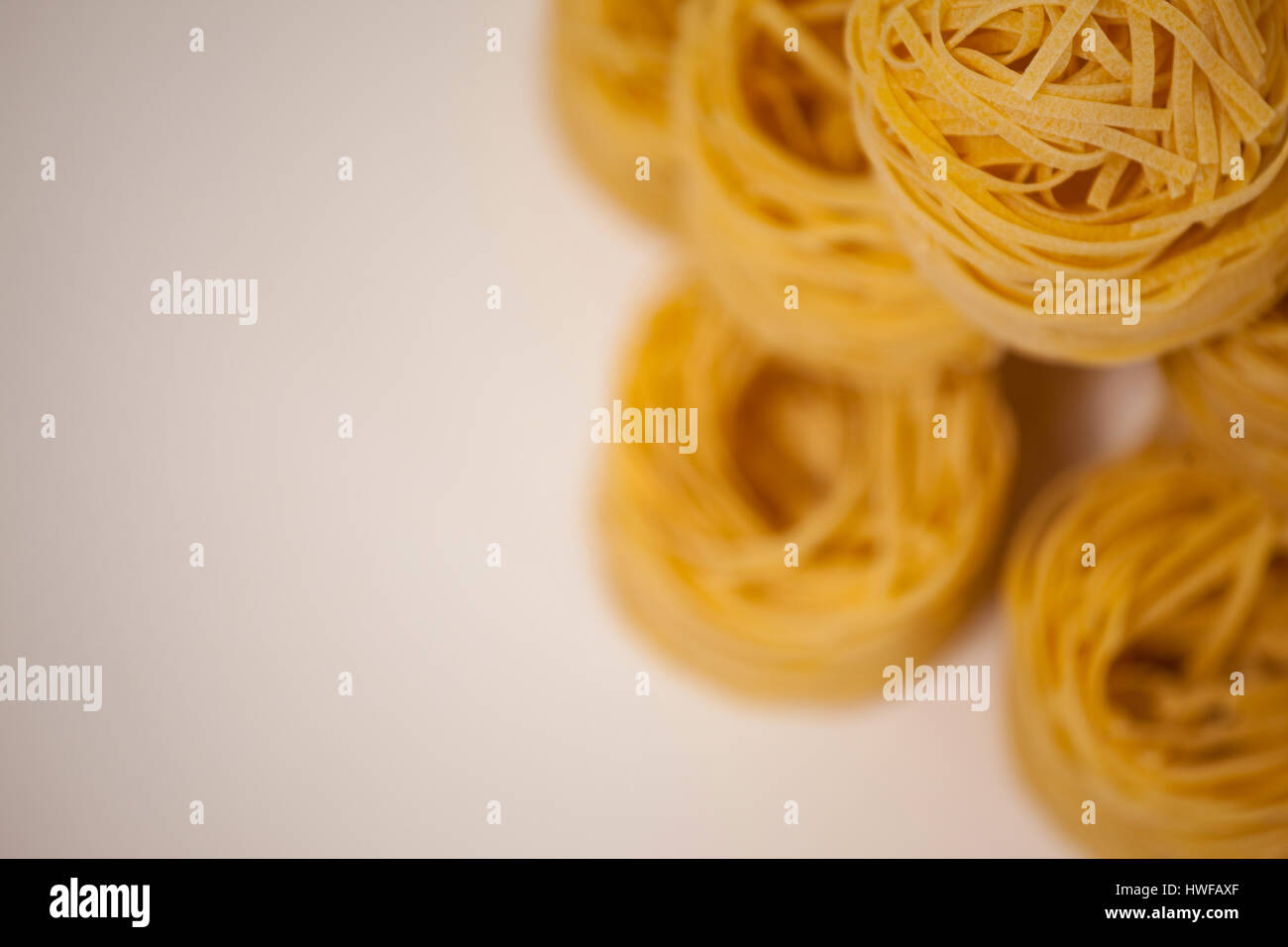 Tagliatelle pasta arranged in a row on white background Stock Photo - Alamy