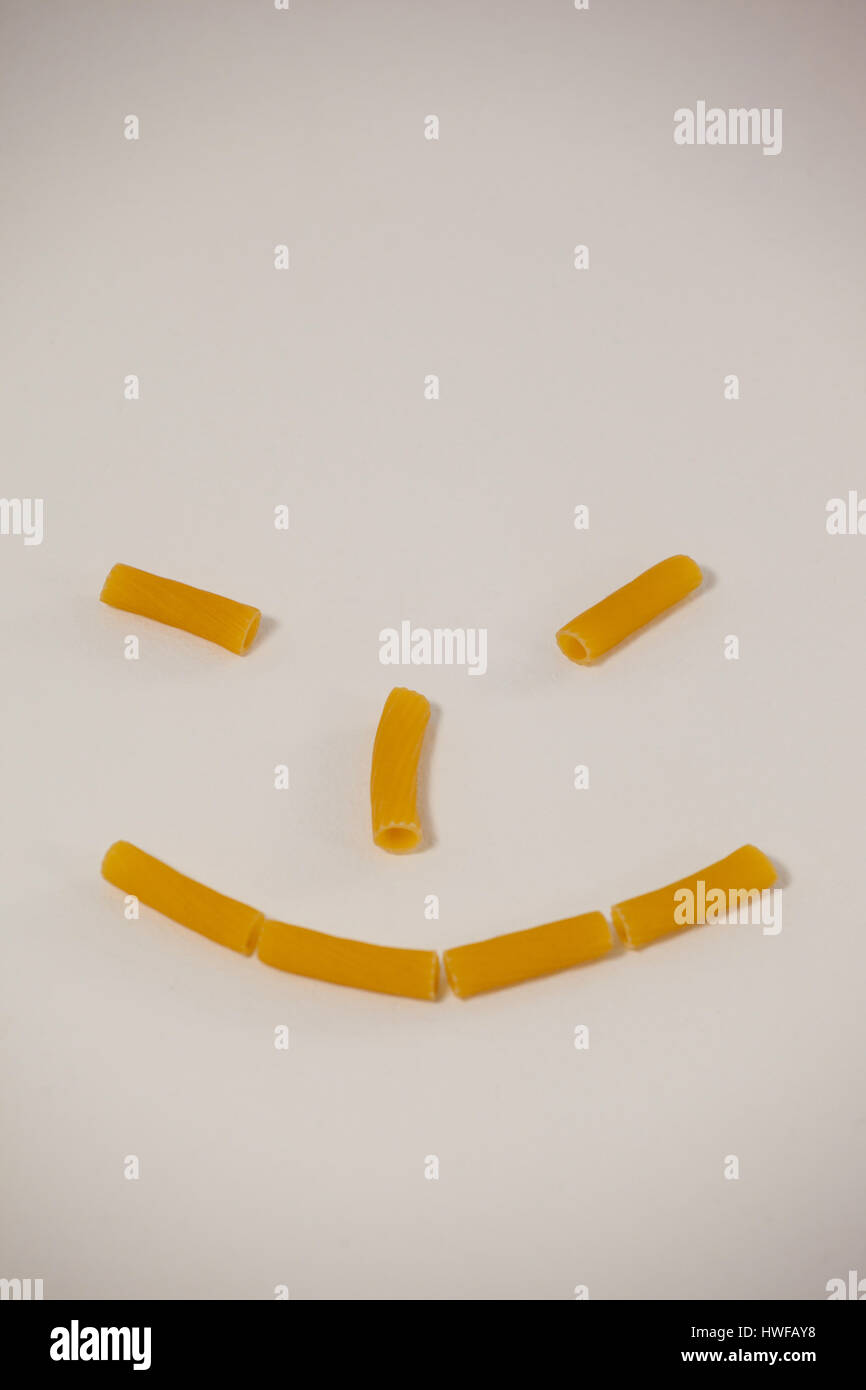 Smiley face made out of pennette pasta on white background Stock Photo ...