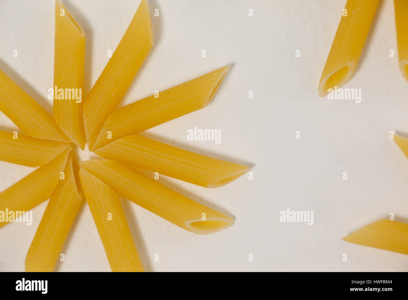 Flowers formed of pennette pasta on white background Stock Photo - Alamy