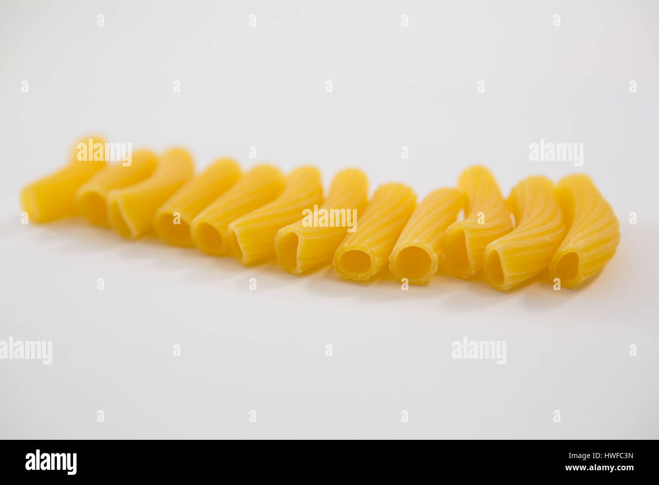 Sedani rigati pasta arranged in row on white background Stock Photo - Alamy