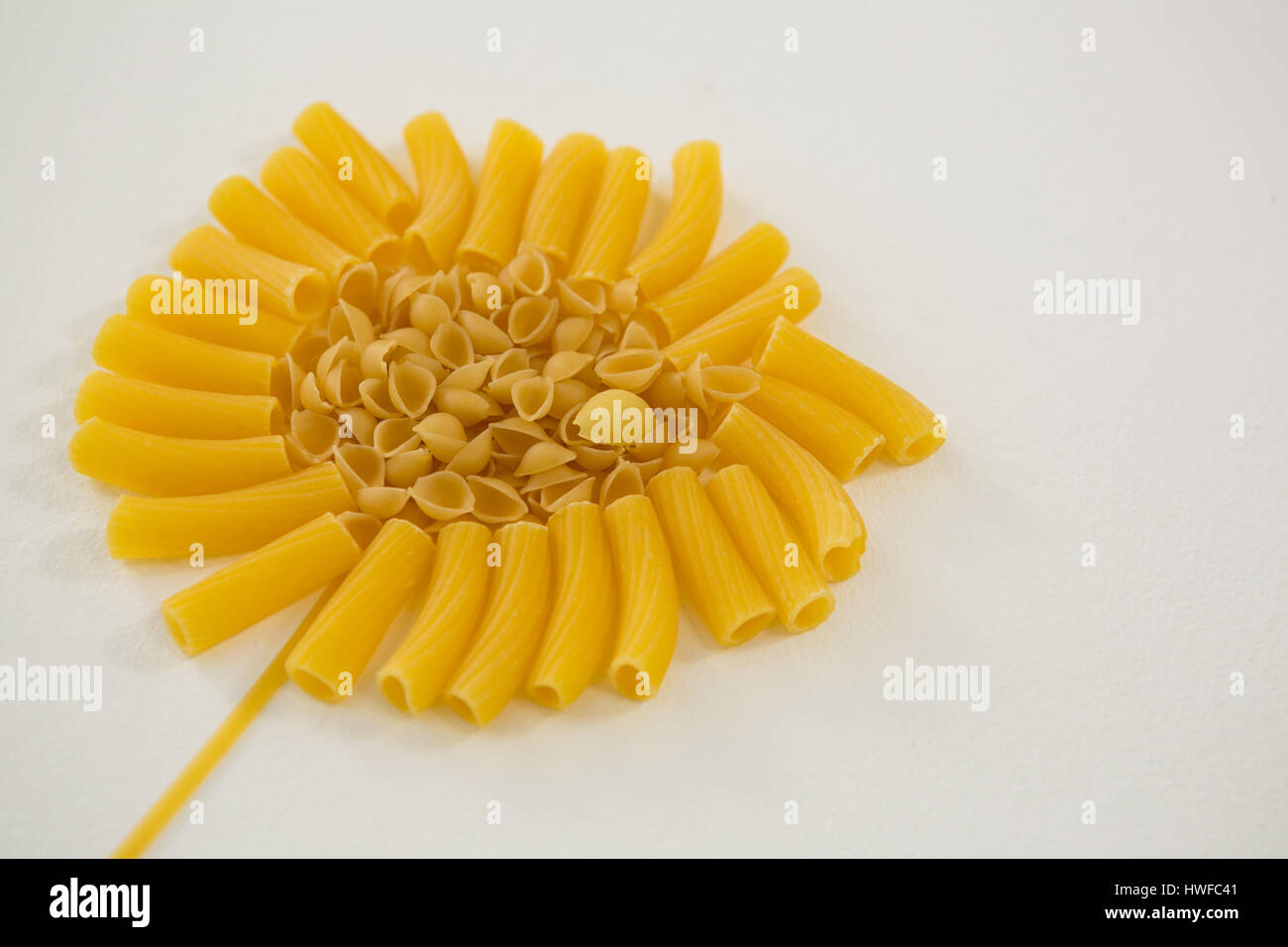 Varieties of pasta forming flower on white background Stock Photo - Alamy