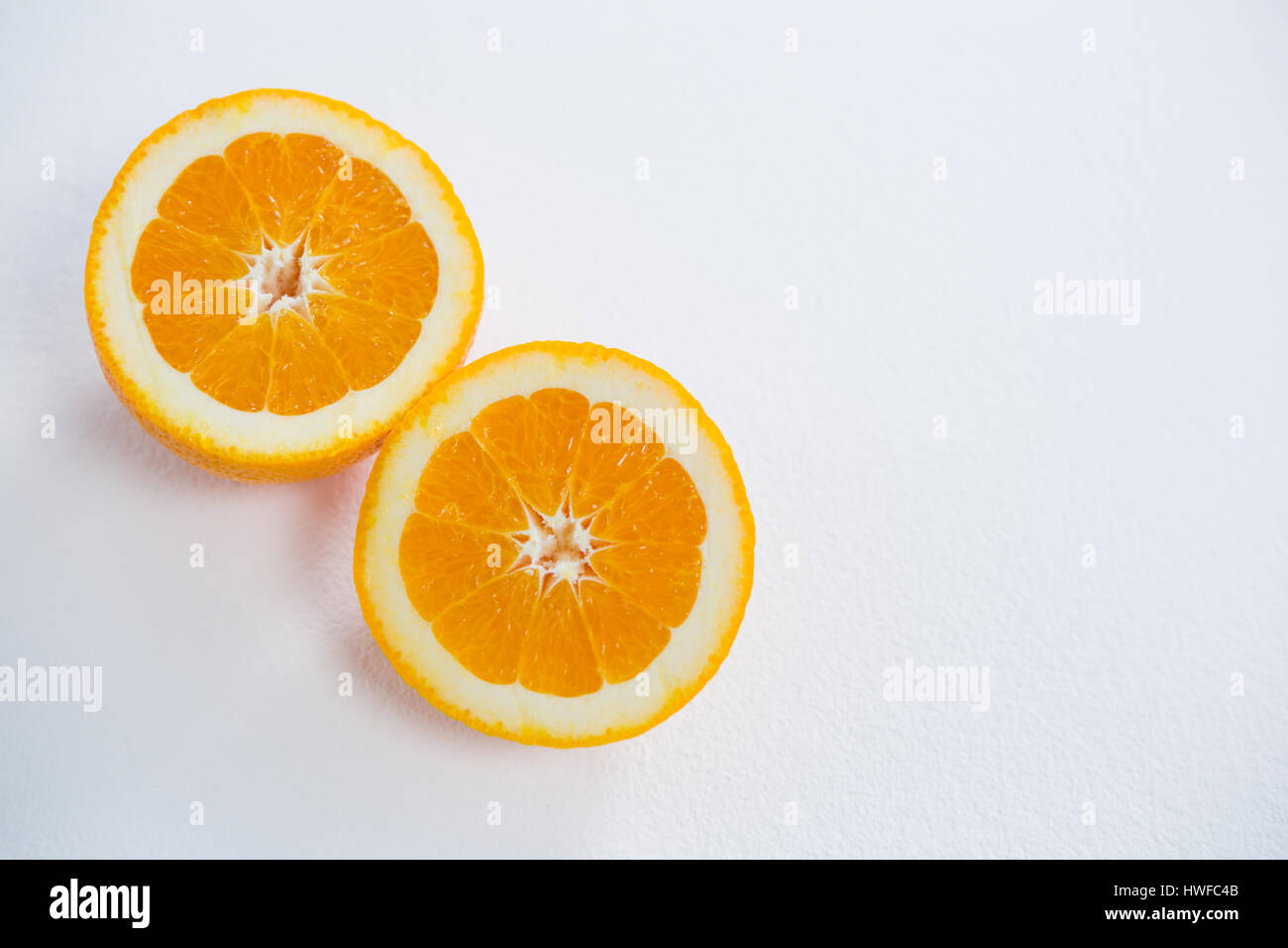 Ripe tasty orange cut into two halves on white background Stock Photo ...