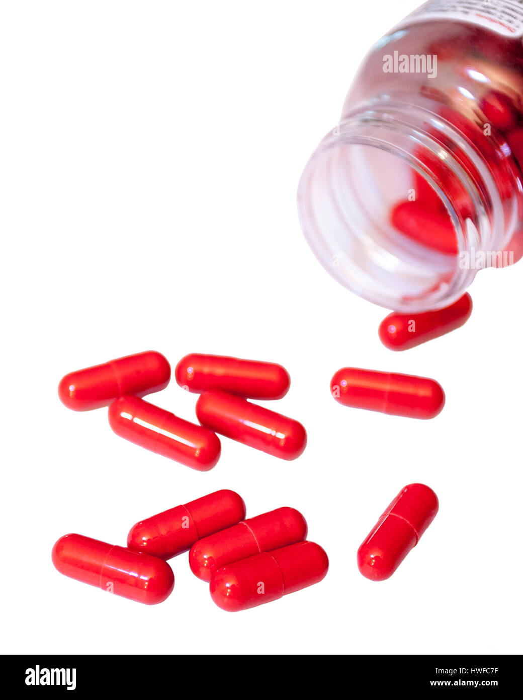 Red vitamin capsules nutritional supplements spilling out of plastic ...