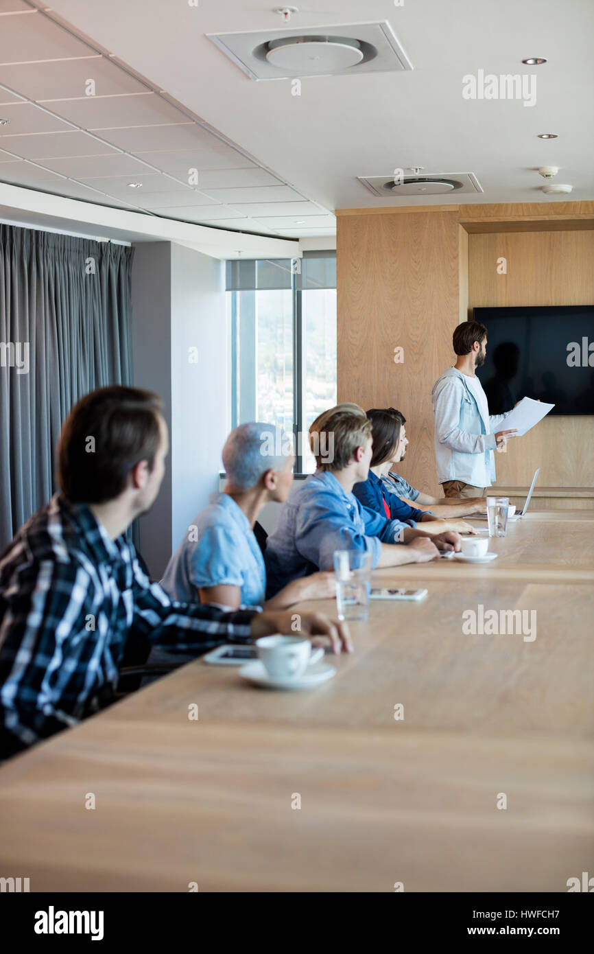 Man giving presentation to her colleagues in conference room at office ...