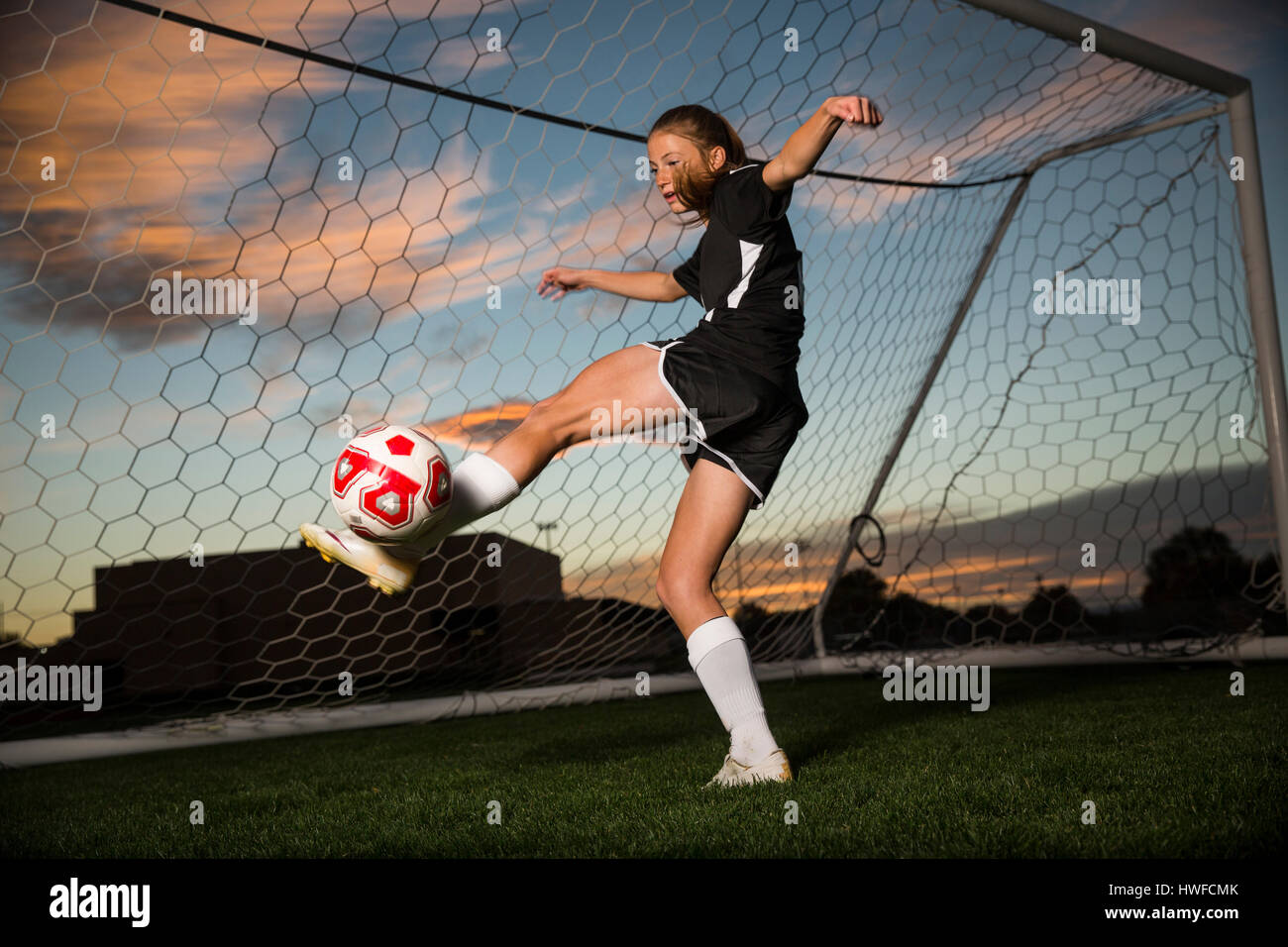 Soccer Player Kicking Ball Into Goal
