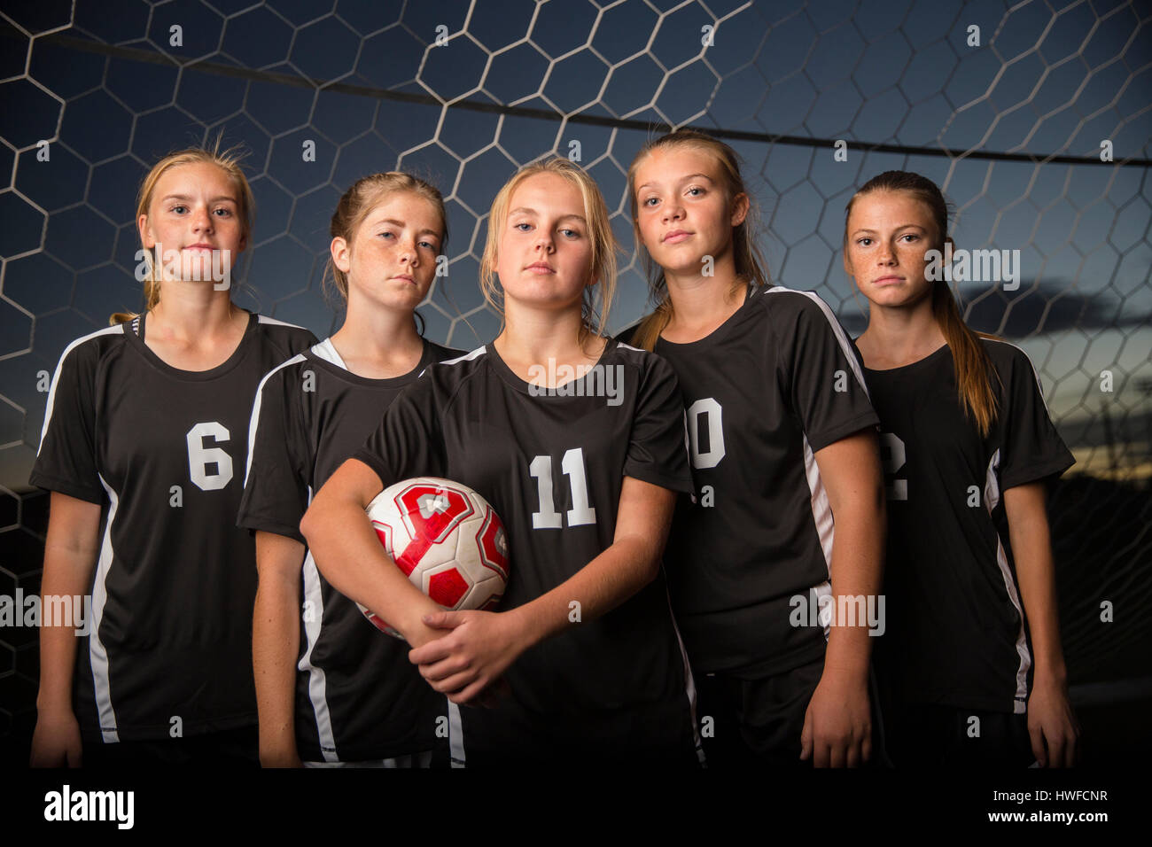 Portrait of serious soccer team standing in goal under sunset sky Stock ...