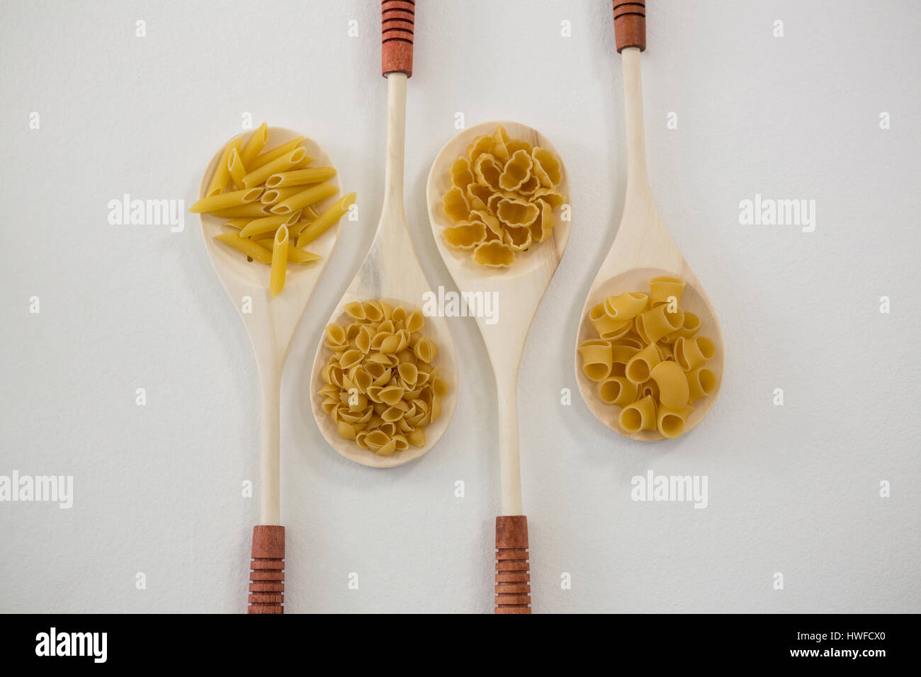Spoons filled with varieties of pasta on white background Stock Photo ...