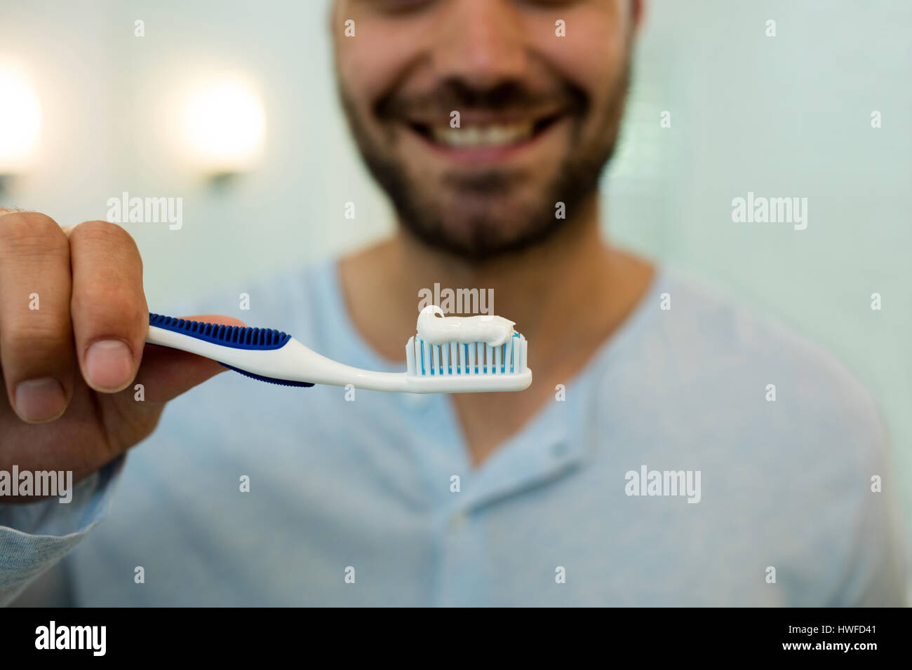 Man holding up toothbrush smiling hi-res stock photography and images ...