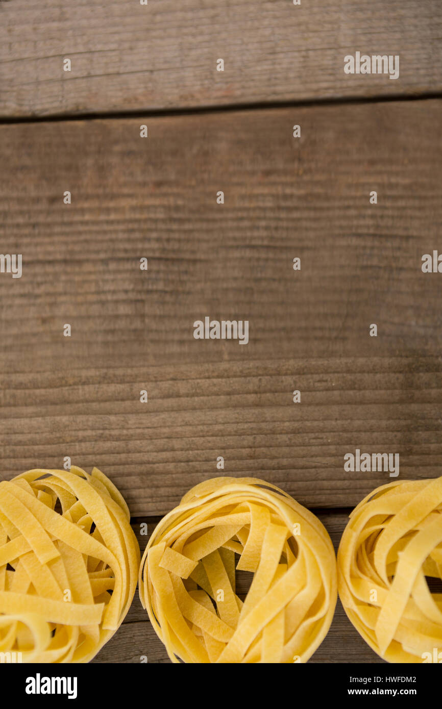 Fettuccine pasta arranged in a row on wooden background Stock Photo - Alamy