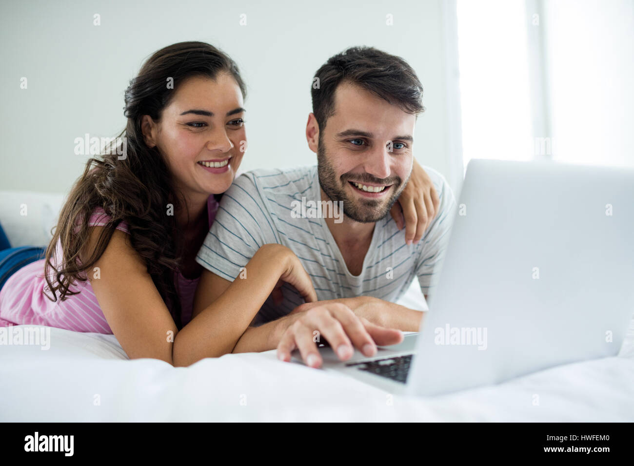 Couple using laptop in the bedroom at home Stock Photo - Alamy
