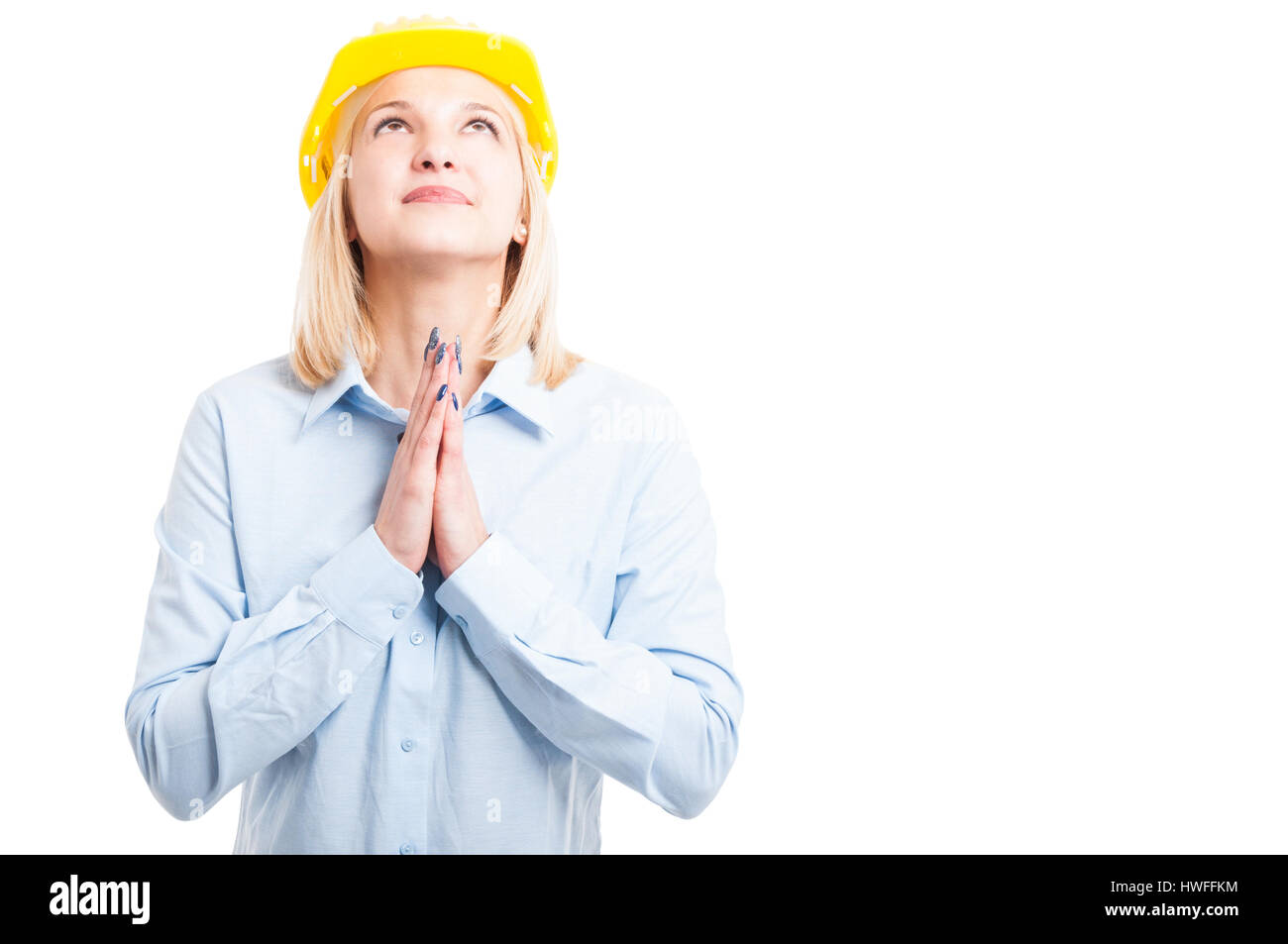 Portrait woman engineer making praying gesture and looking up isolated ...