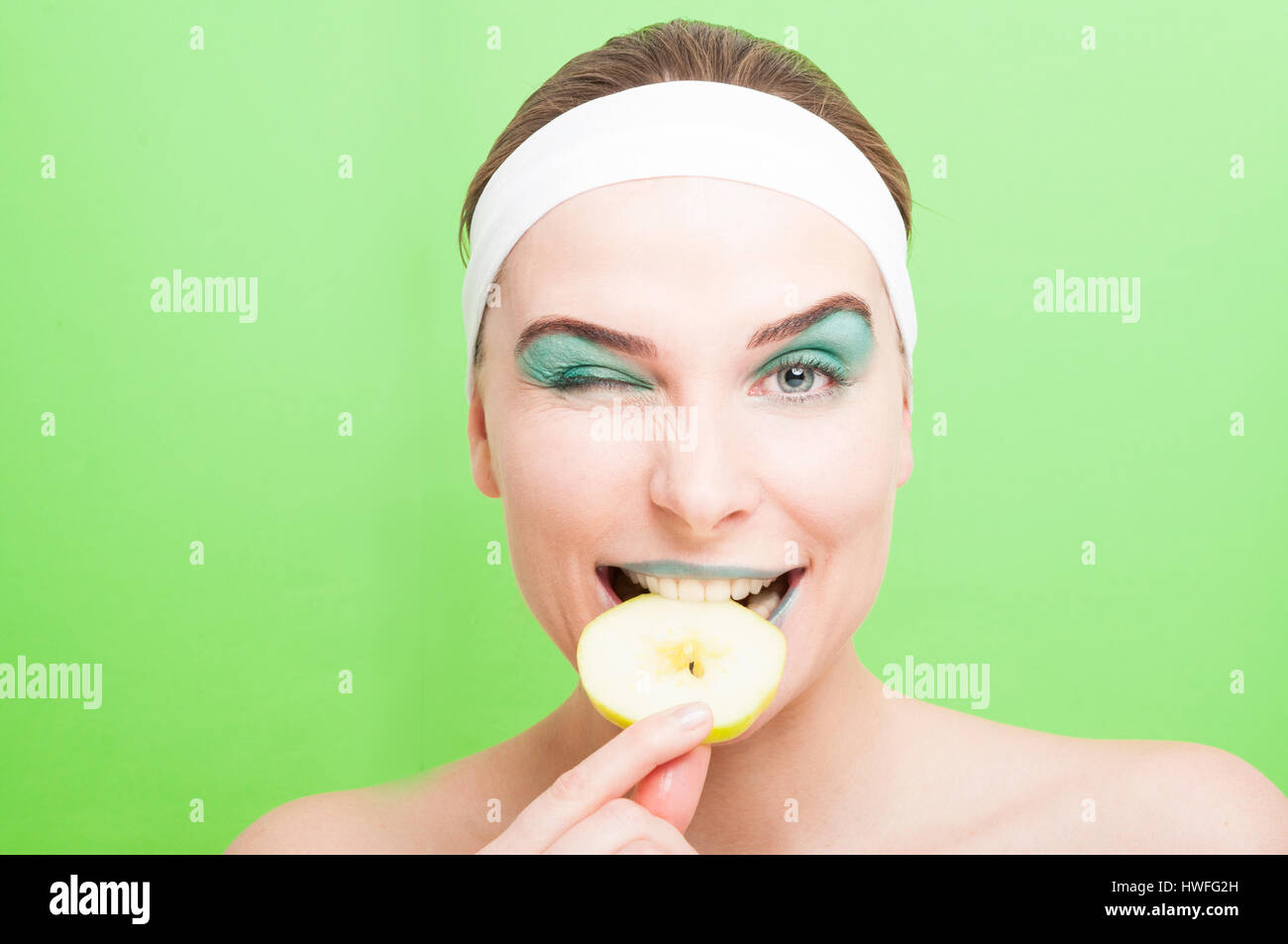 Cute portrait of female bite a slice of fresh apple as detox concept ...