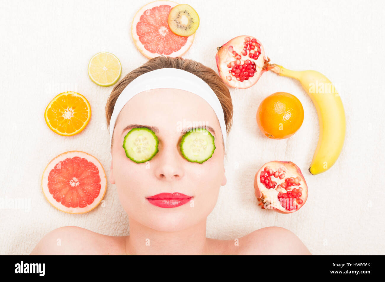 Fruit facial mask concept with young girl at dayspa relaxing with two ...