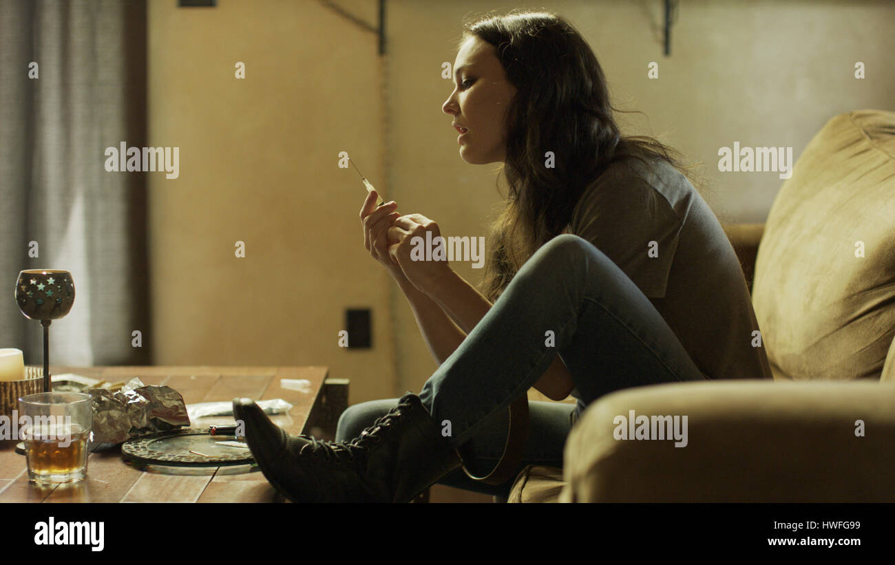 Profile of drug addict loading syringe needle for injection on dingy ...