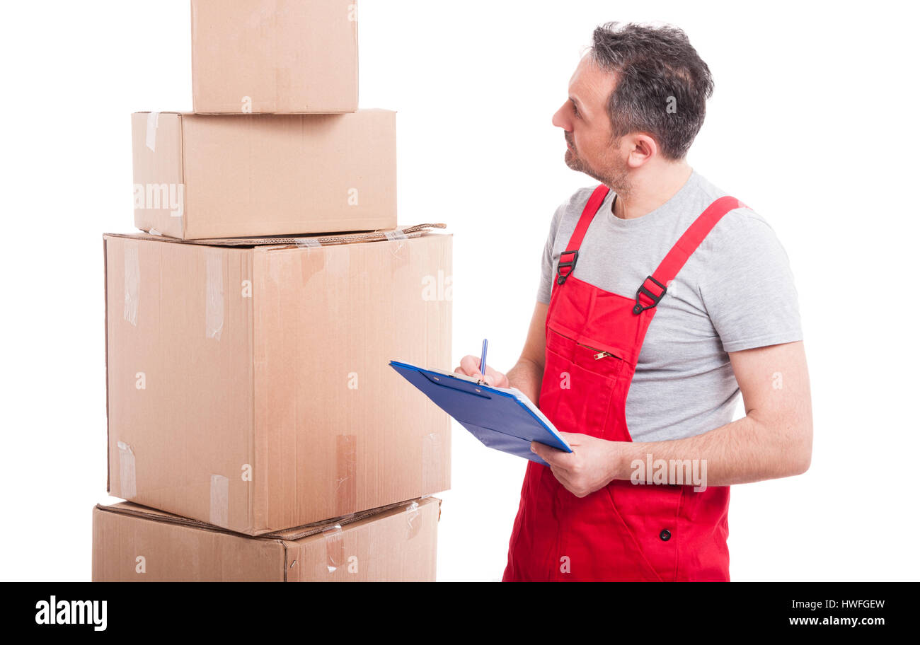 Mover guy counting or writing on clipboard with cardboard boxes around ...