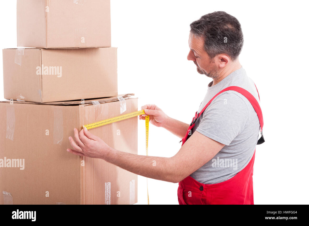 Mover man measuring one big cardboard box with measuring tape isolated ...