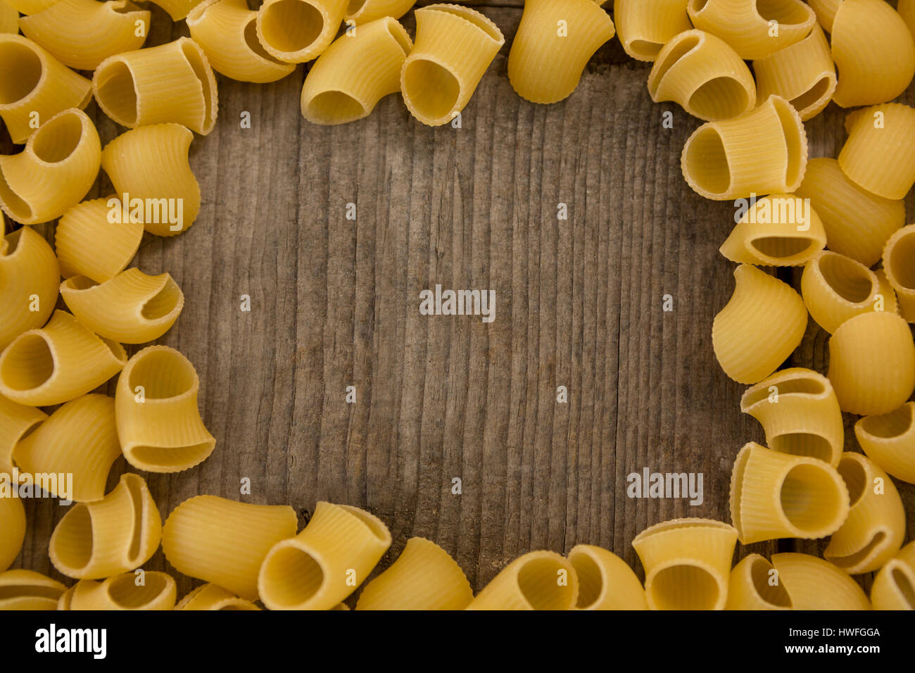 Raw lumache rigate pasta arranged on wooden surface Stock Photo - Alamy